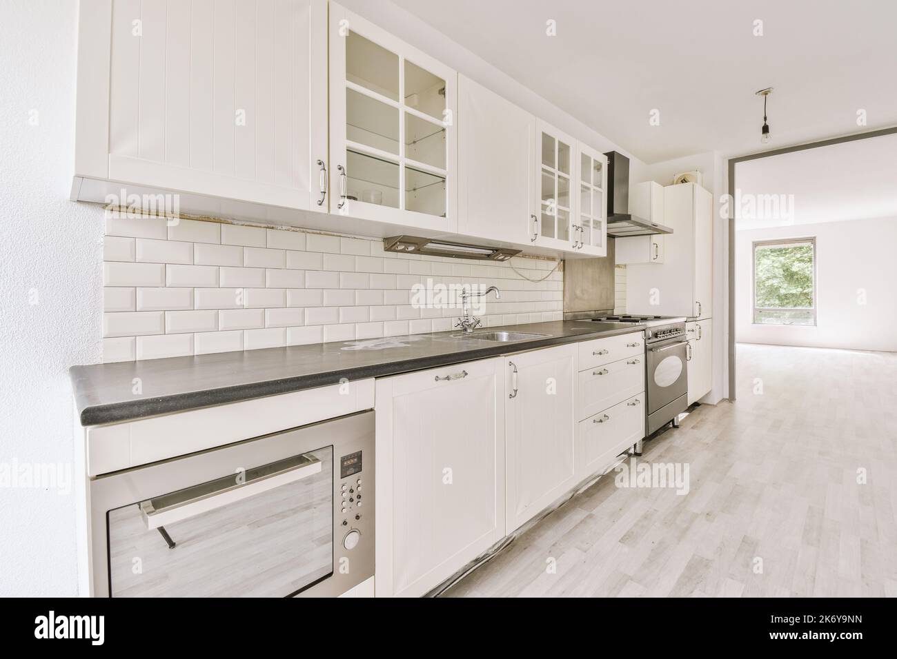 Interior of empty white kitchen with windows and wooden parquet floor ...