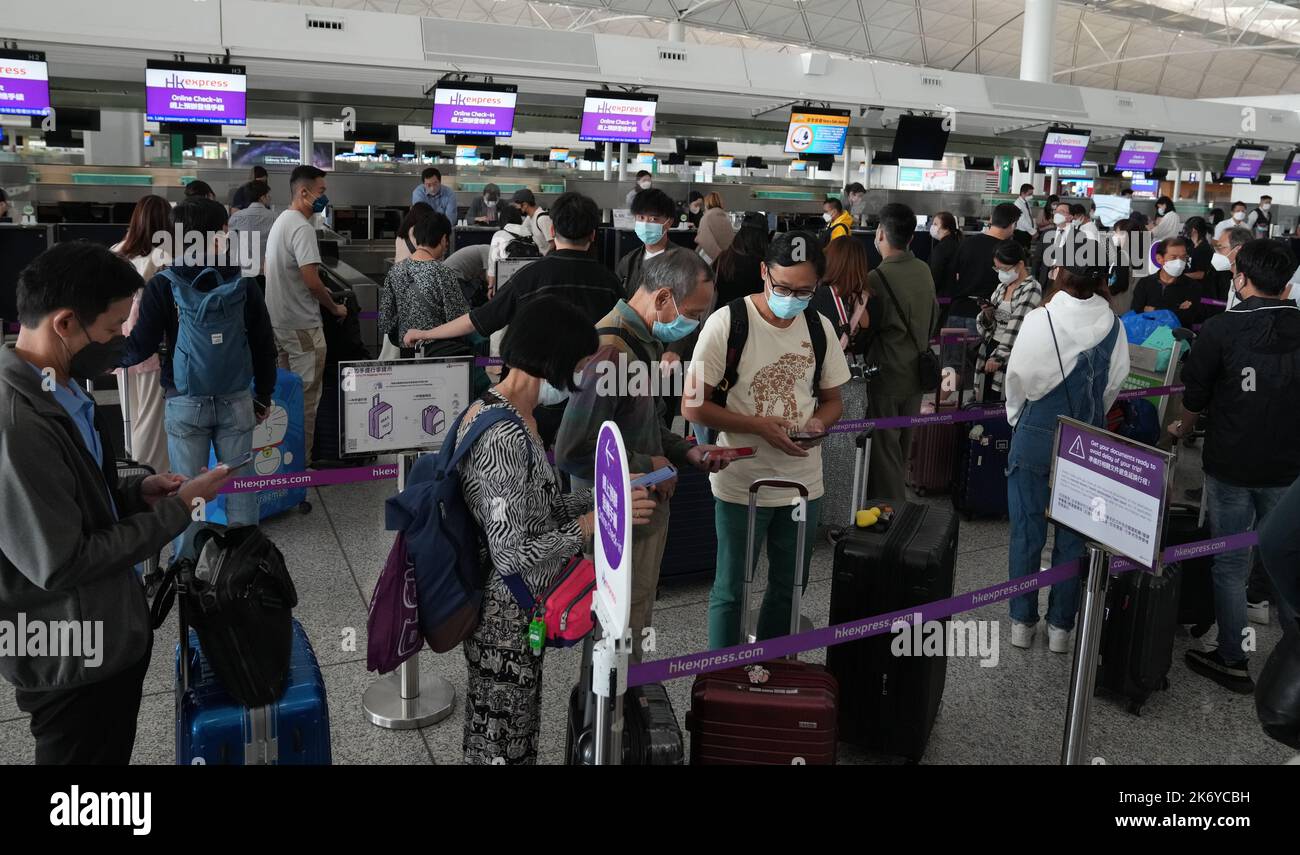 Outbound passengers queue up at check-in counters in the departure hall ...