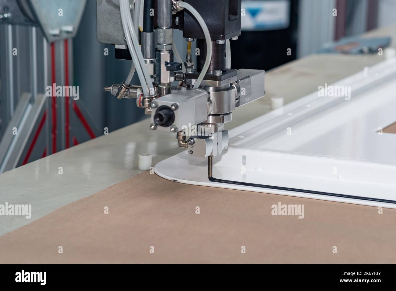 industrial robotic dosing dispenser machine applies a hardening sealant ...