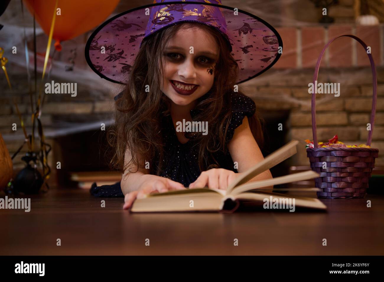 Pretty child girl with face art makeup, looking like a witch posing ...