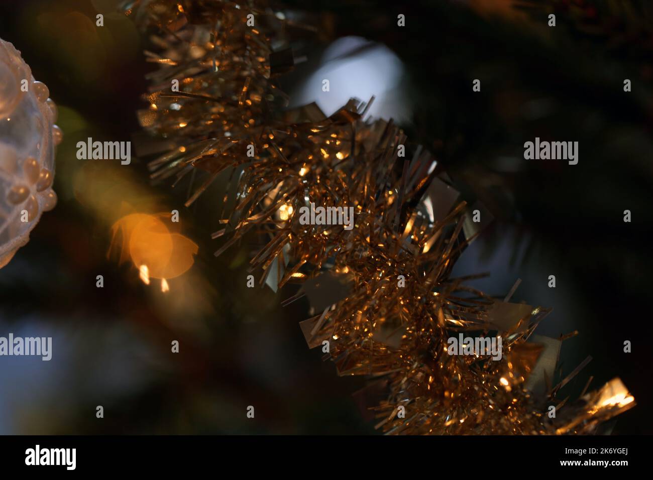 Closeup of Christmas tree branch with golden tinsel and some fake ...