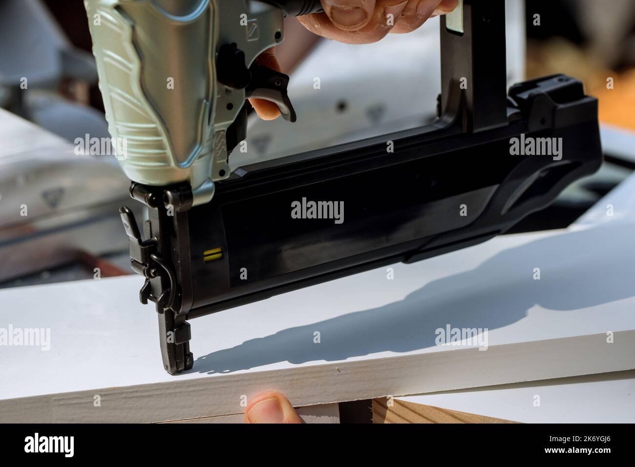 Aid of pneumatic air gun carpenter connects wood board assemblies with ...