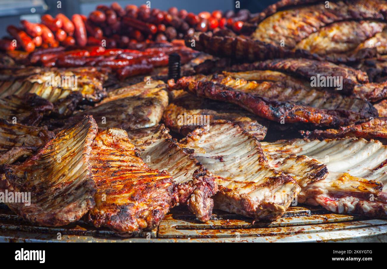 Huge circular grill loaded with pork ribs. Selective focus Stock Photo ...