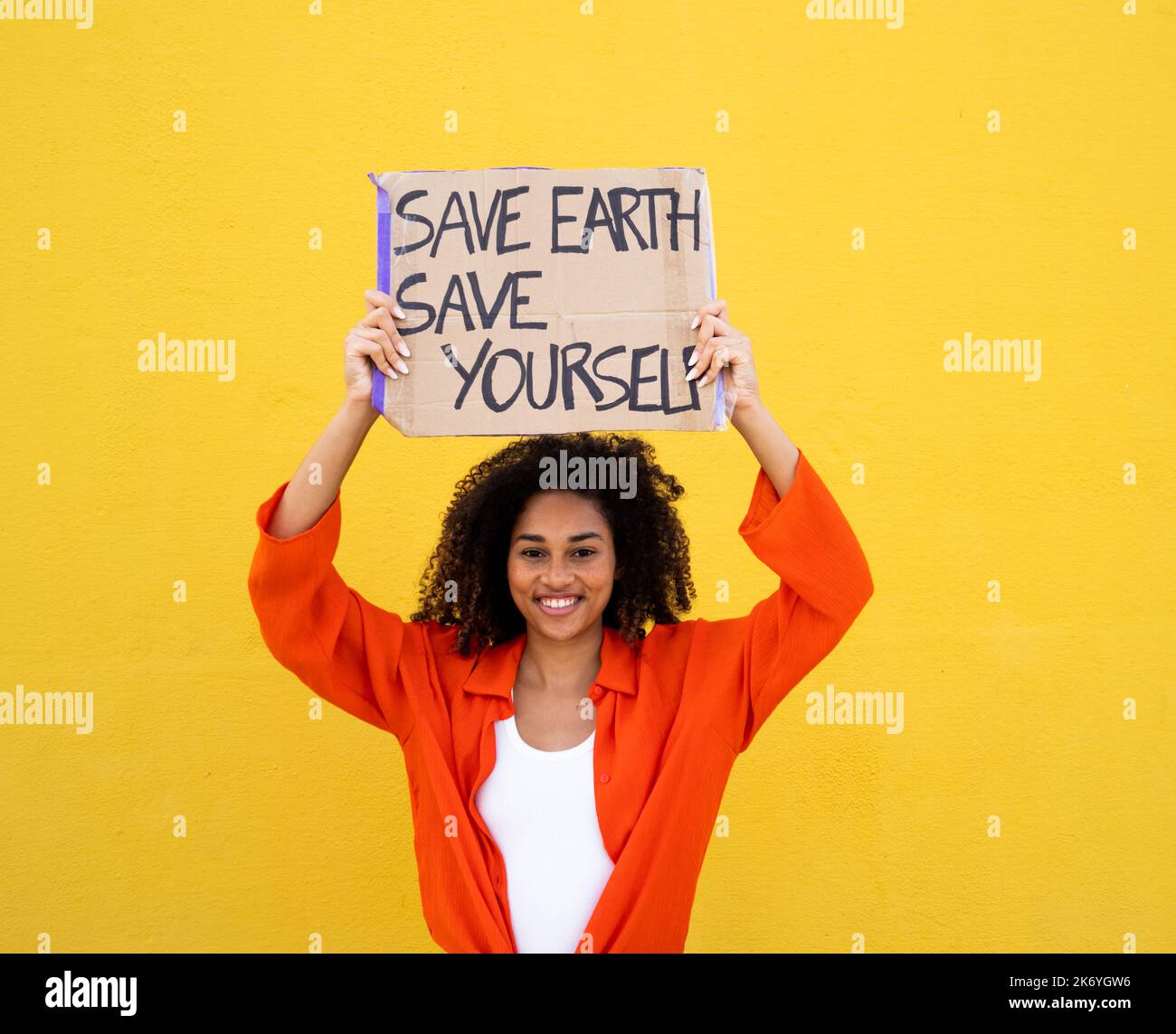 Cheerful African American young woman holding a sign that says: Save ...
