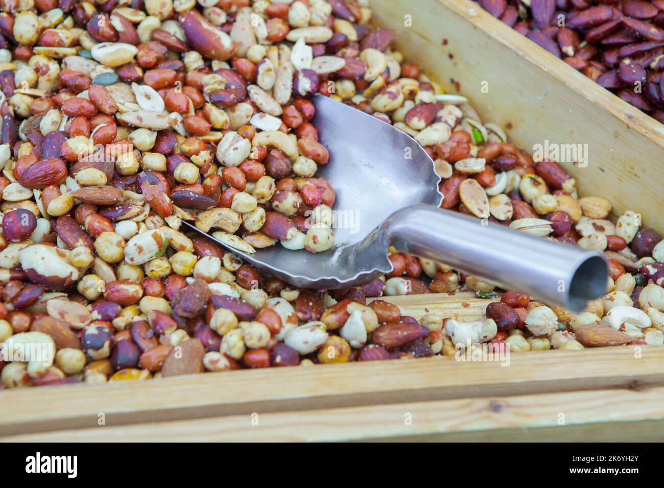 Wooden box with an assortment of fried salty dry fruits. Displayed at ...