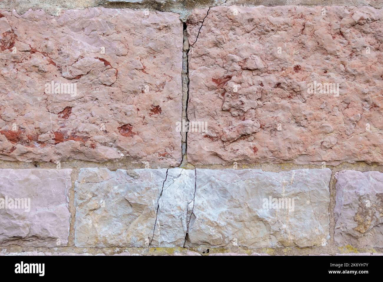 Cracked stone wall of an old ancient building. Weathered damaged ...