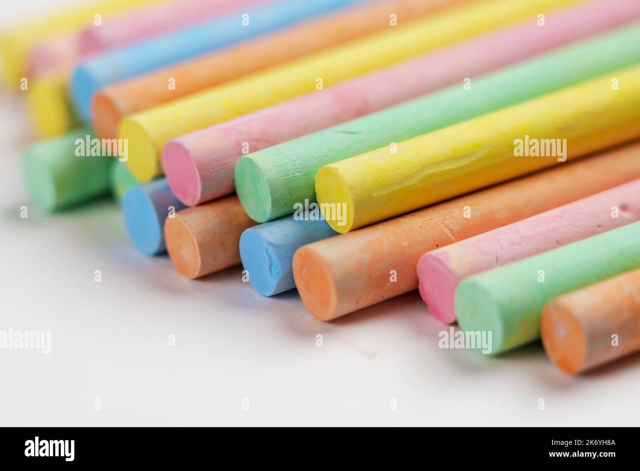Multicolored pastel chalks stacked in a heap on a white paper ...
