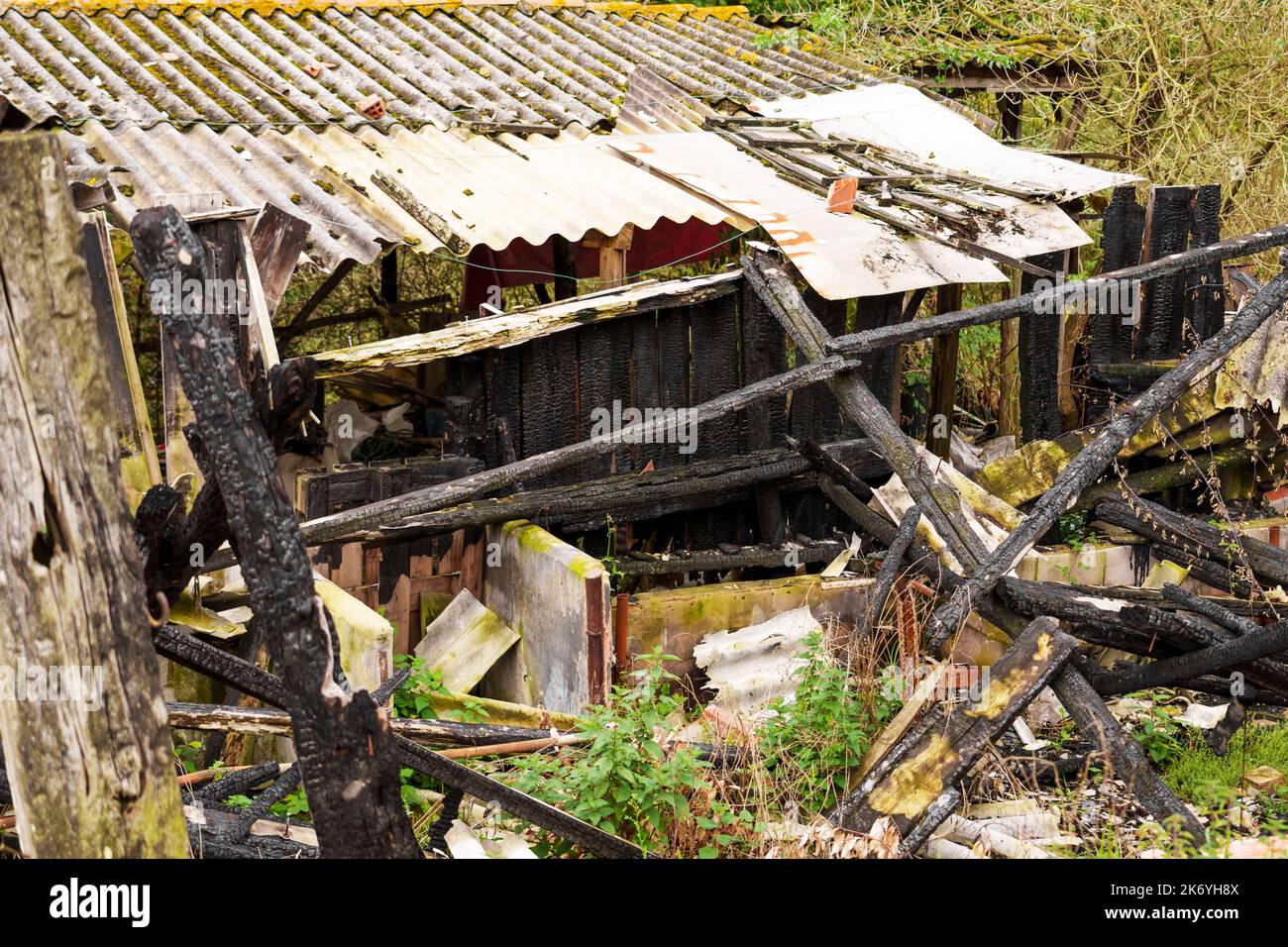 Burnt by fire charred residential rural house. Ruined building. Arson ...