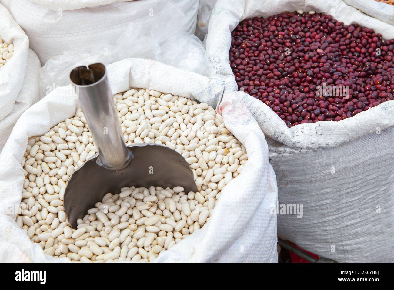 White and red beans in rolled up sacks. Displayed at street market ...