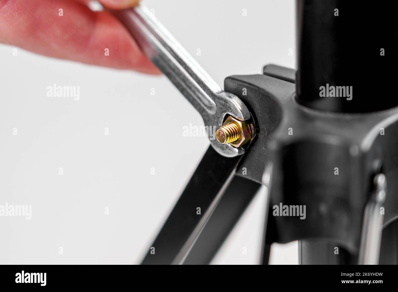 Wrench tightening a nut on a threaded bolt, fixing the photo tripod ...