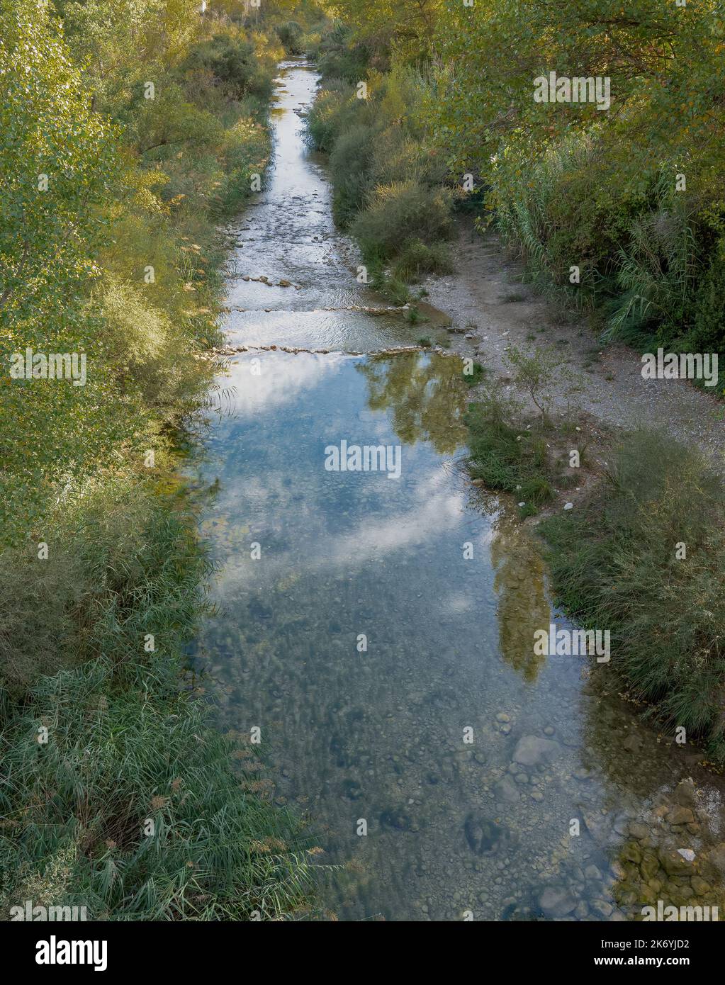 small stream with man-made mini waterfalls, weirs running along a grass ...