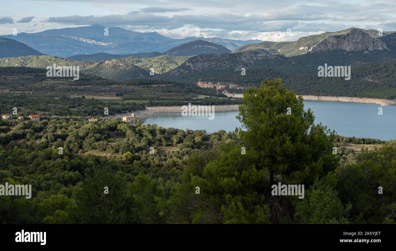 view over a village nestled on the banks of the Embalse de Mediano ...