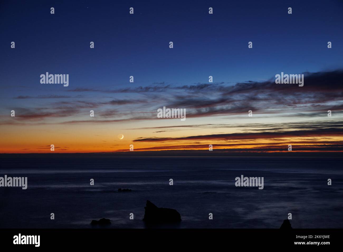 Starry sky during twilight with a view of the ocean and the moon Stock ...