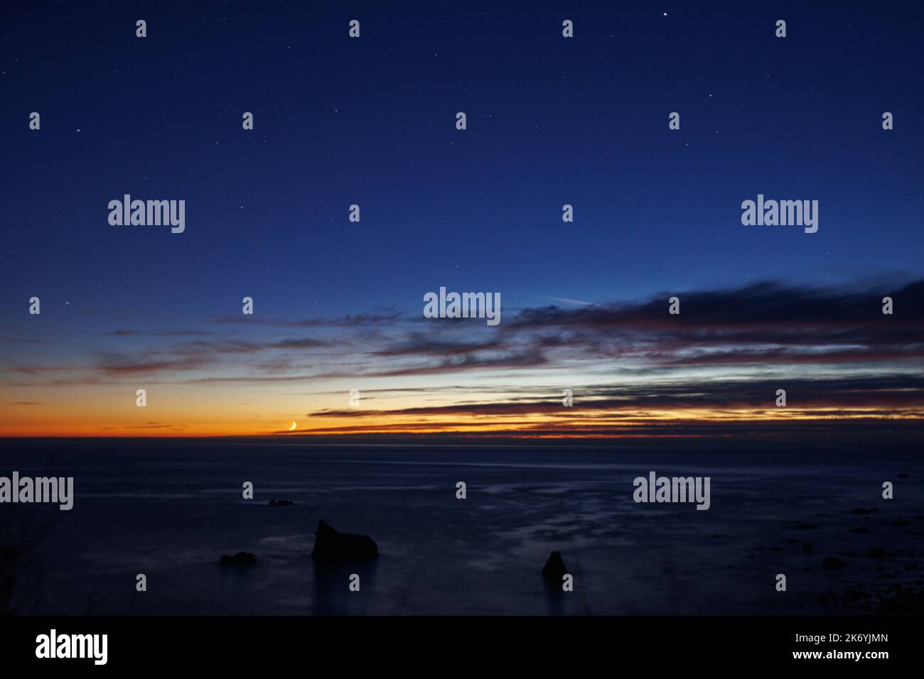 Starry sky during twilight with a view of the ocean and the moon Stock ...