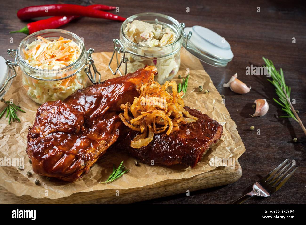 Two steaks with barbecue sauce fried onions and two glass jars of ...