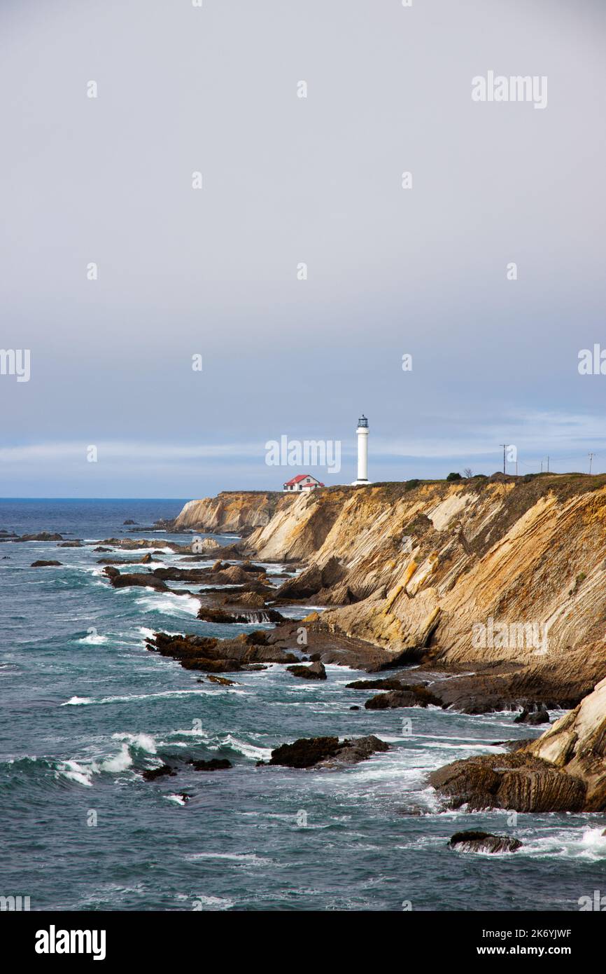 View of Point Arena Lighthouse on a rocky seashore in California by ...