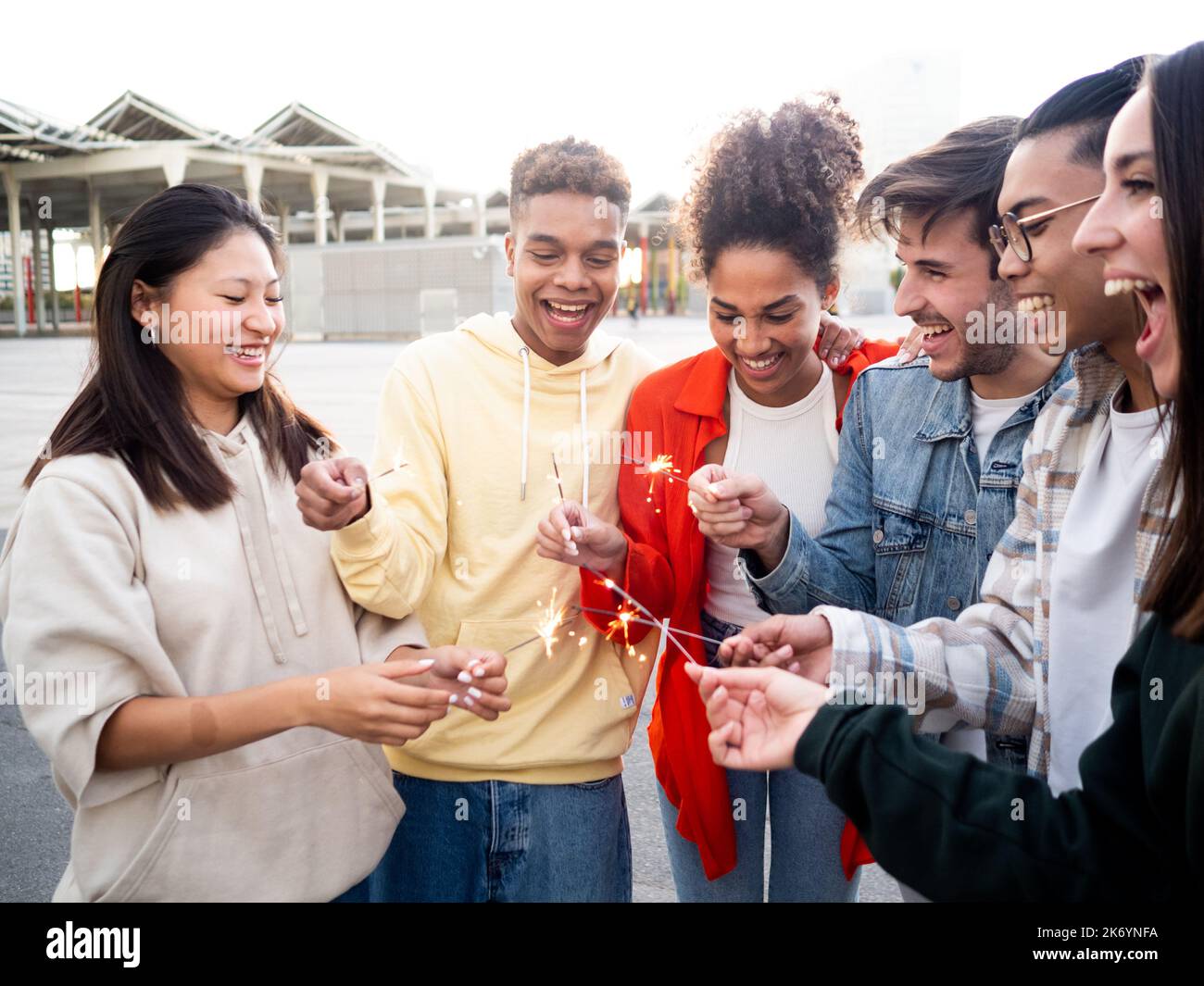 Group of diverse millennial young friends having fun with sparklers ...