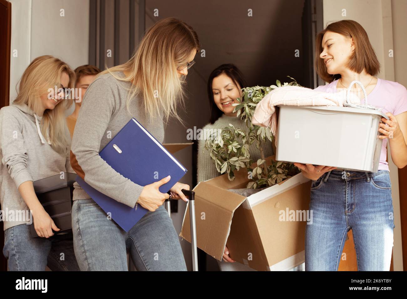 Concentrated, positive female students moving out old room in campus to ...