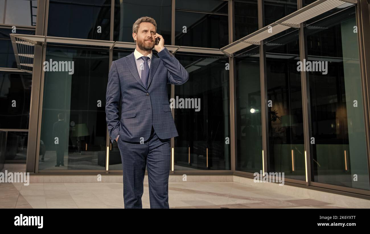 smiling entrepreneur in businesslike suit has phone conversation ...