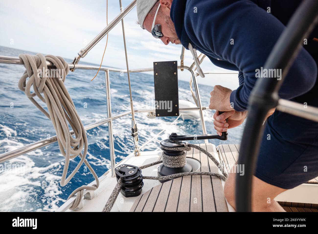 man on winch setting sail in boat regatta Stock Photo - Alamy