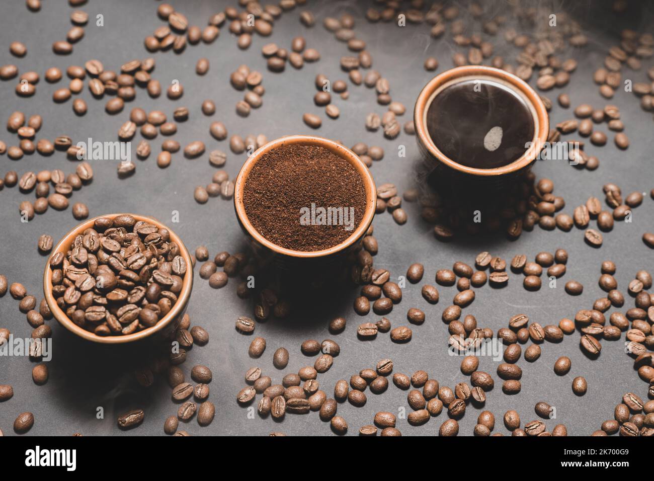 Three cups with different coffee, coffee beans, ground and ready-made ...