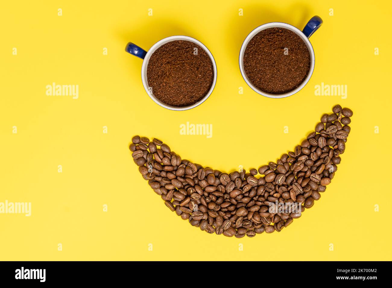 Happy emoticon made of coffee beans on a yellow background Stock Photo ...