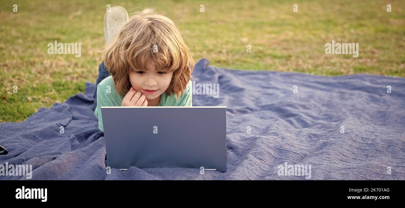 Boy kid use laptop computer learning technology relaxing on blanket ...