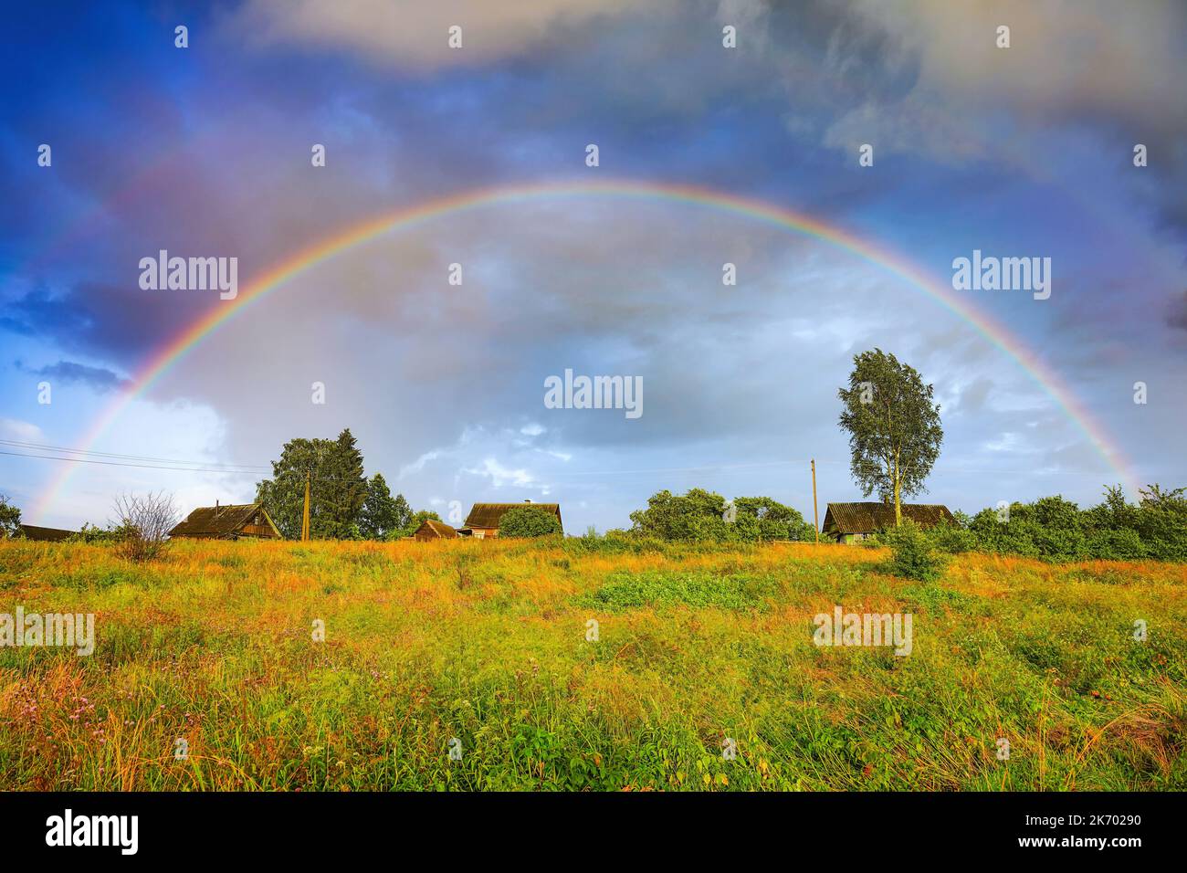 Rainbow over stormy sky in countryside at summer evening Stock Photo ...