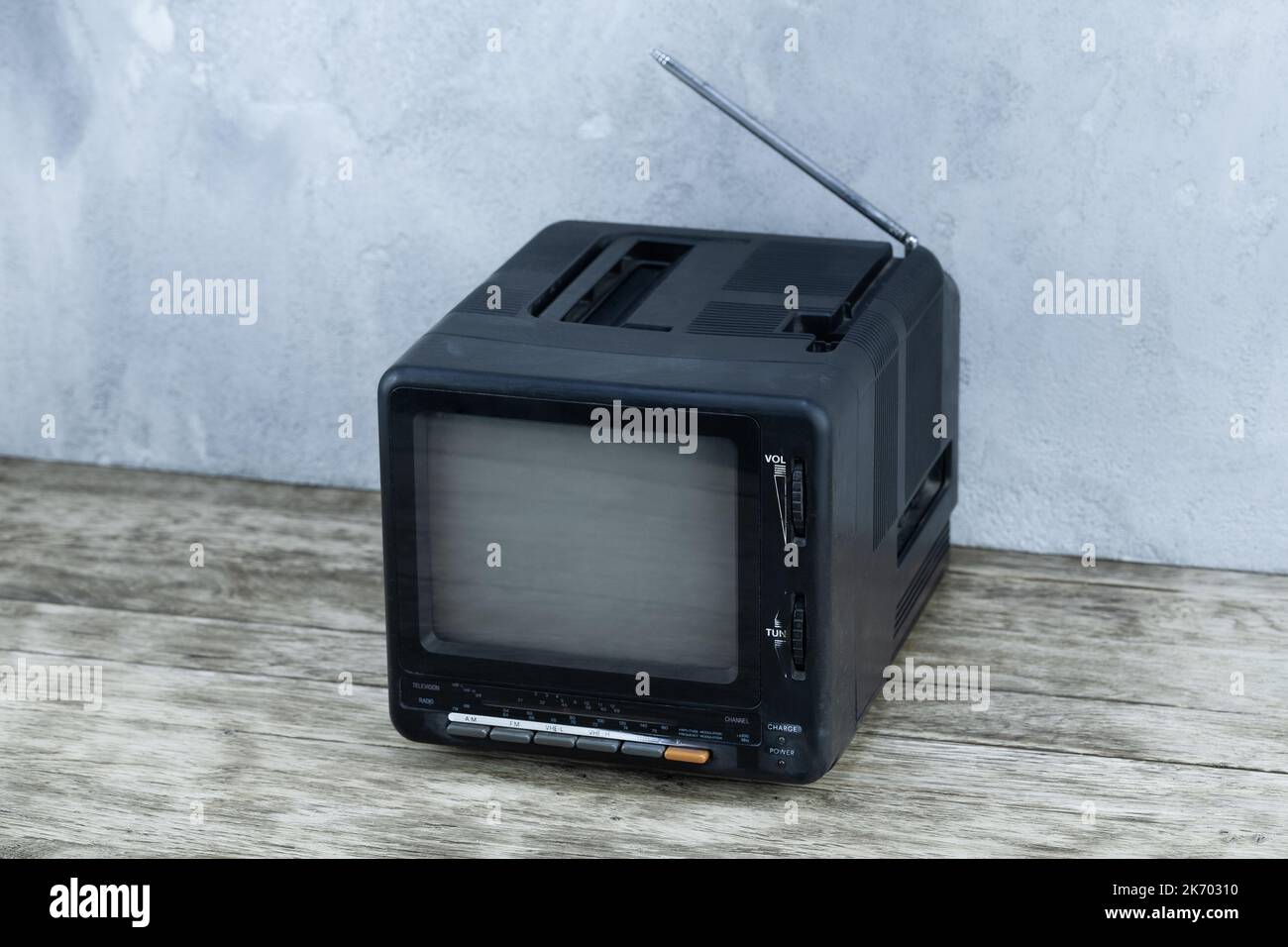 Vintage retro analog small TV set stand on wooden floor front grey ...