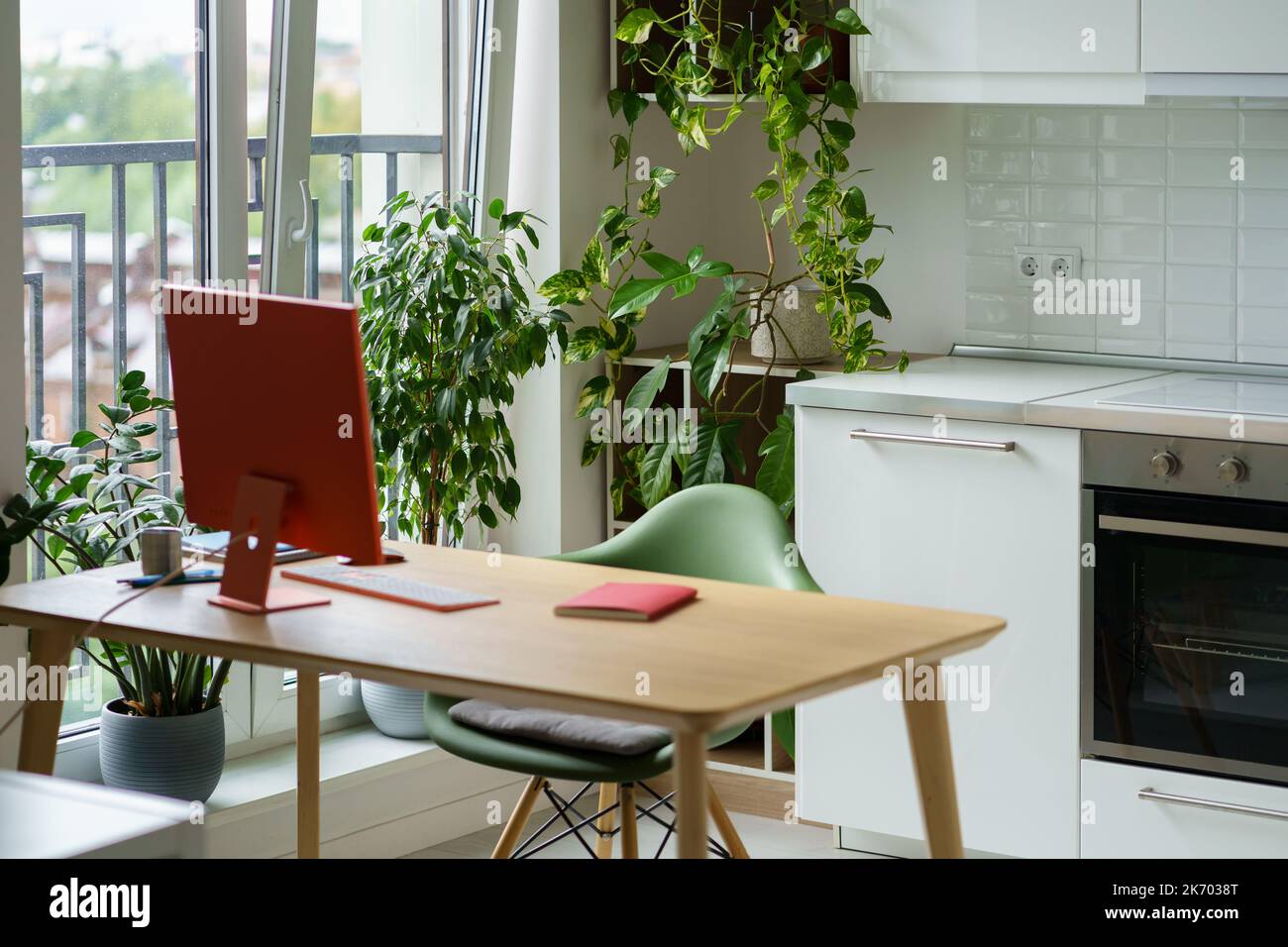 Cozy home office for freelancer with stylish red monitor on table near ...