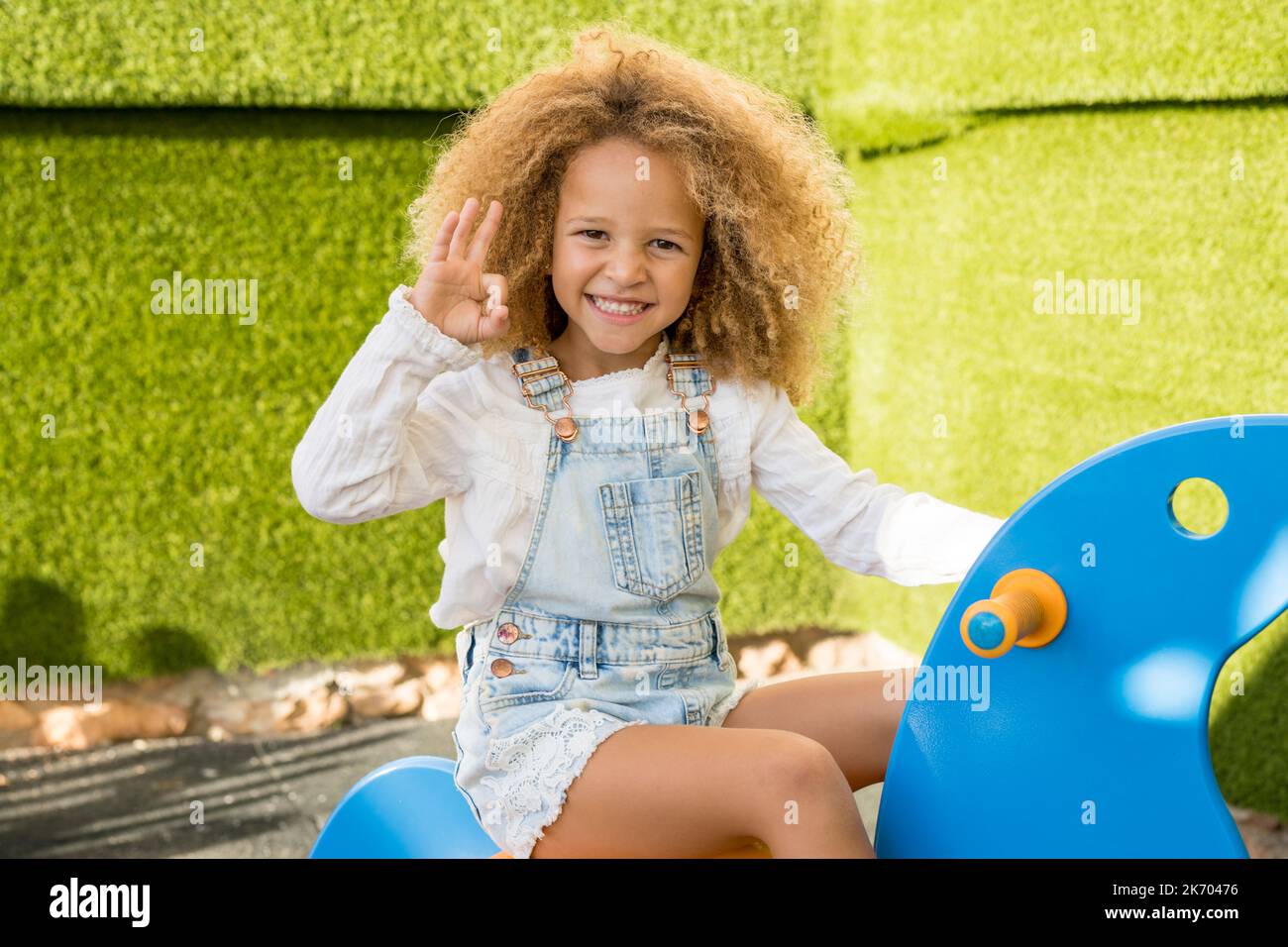 Active beautiful little child girl on playground showing okay sign ...