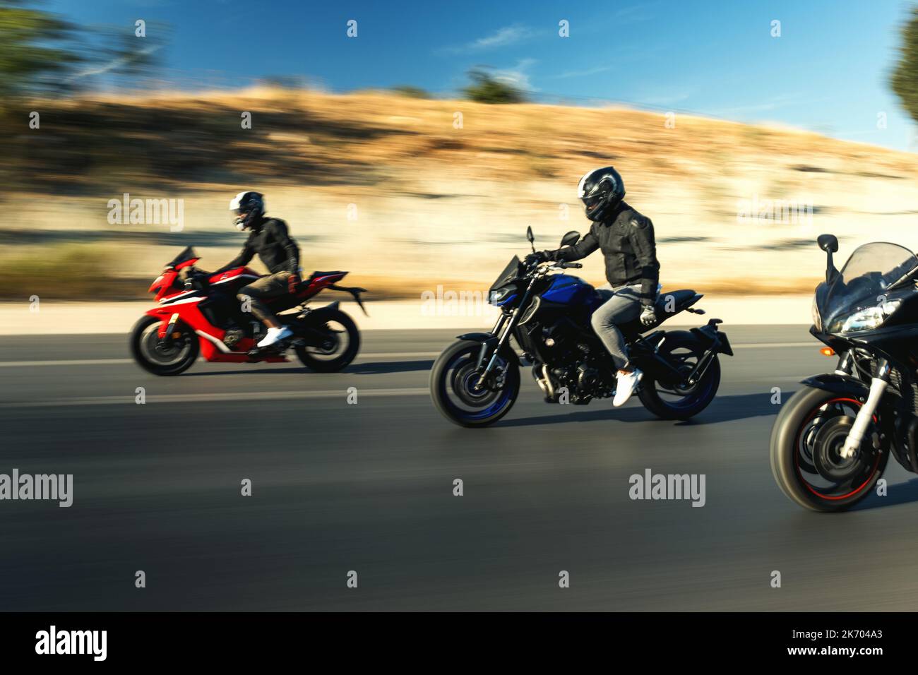 Three supersport race motorcycle riders going fast side by side on the ...