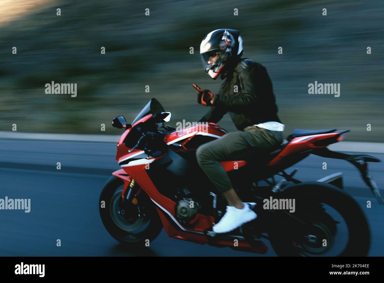 Side view of a motorcycle rider riding red race motorcycle on the ...
