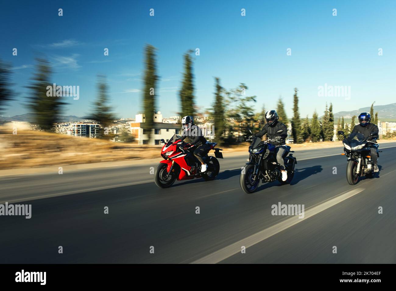 Three supersport race motorcycle riders going fast side by side on the ...