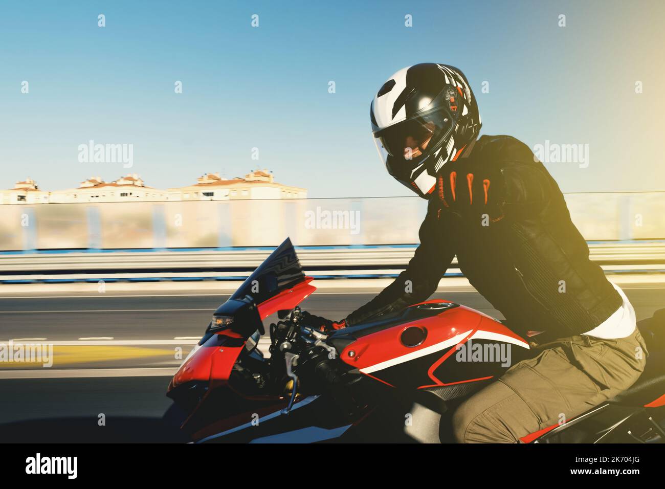 Side view of a motorcycle rider riding red race motorcycle on the ...