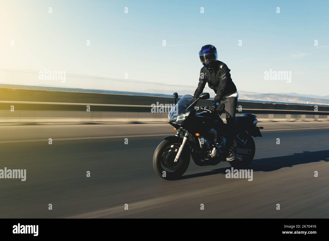 Side view of a motorcycle rider riding race motorcycle on foot on the ...