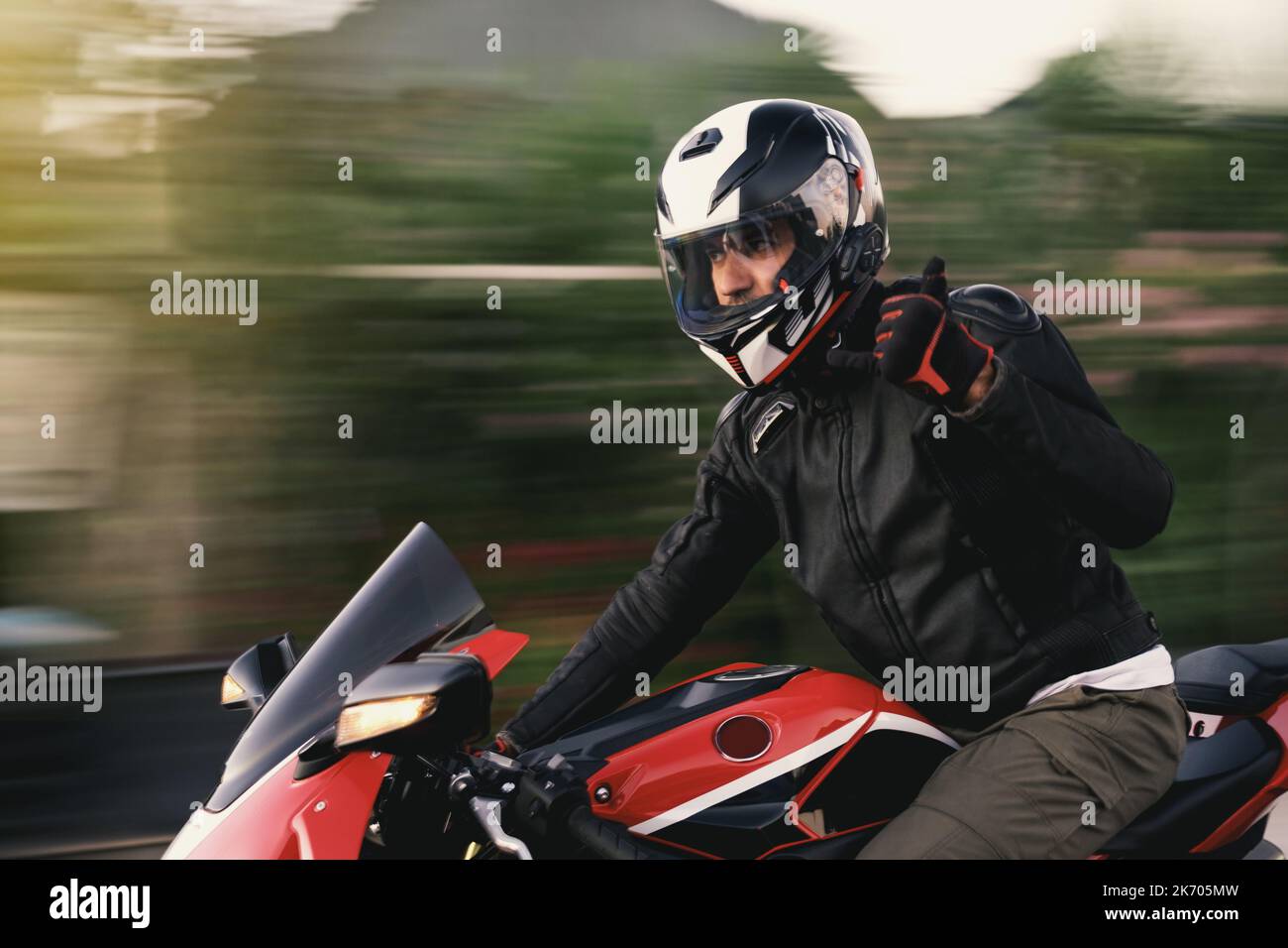 Side view of a motorcycle rider riding red race motorcycle on the ...
