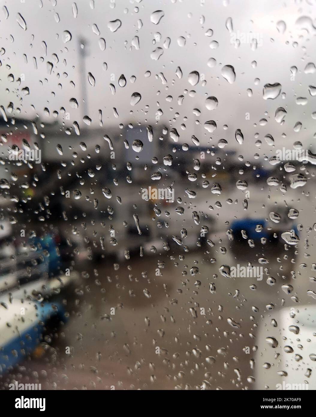 Raindrops on airplane window glass during boarding on a rainy summer ...