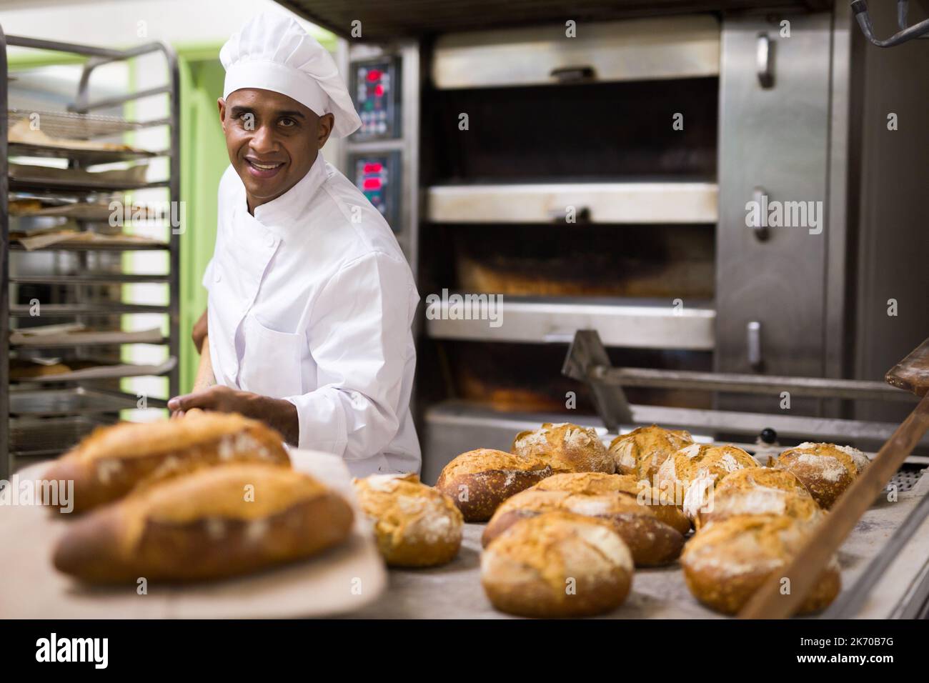 male baker with bread on baking shovel in kitchen Stock Photo - Alamy