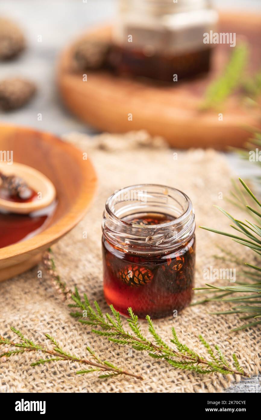 Pine cone jam with herbal tea on gray wooden background and linen ...