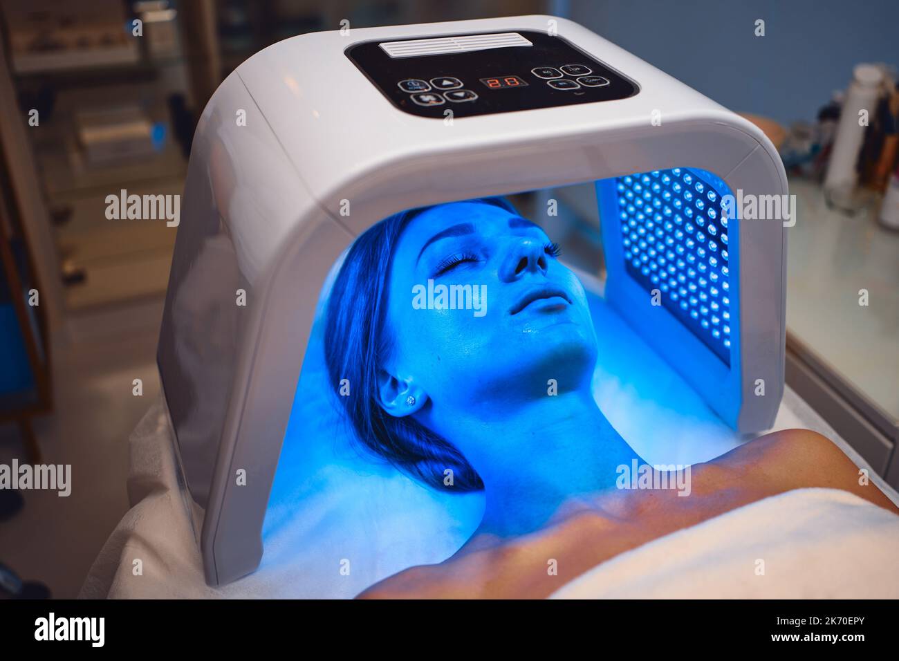 LED red light is treating the facial skin of a young woman Stock Photo ...