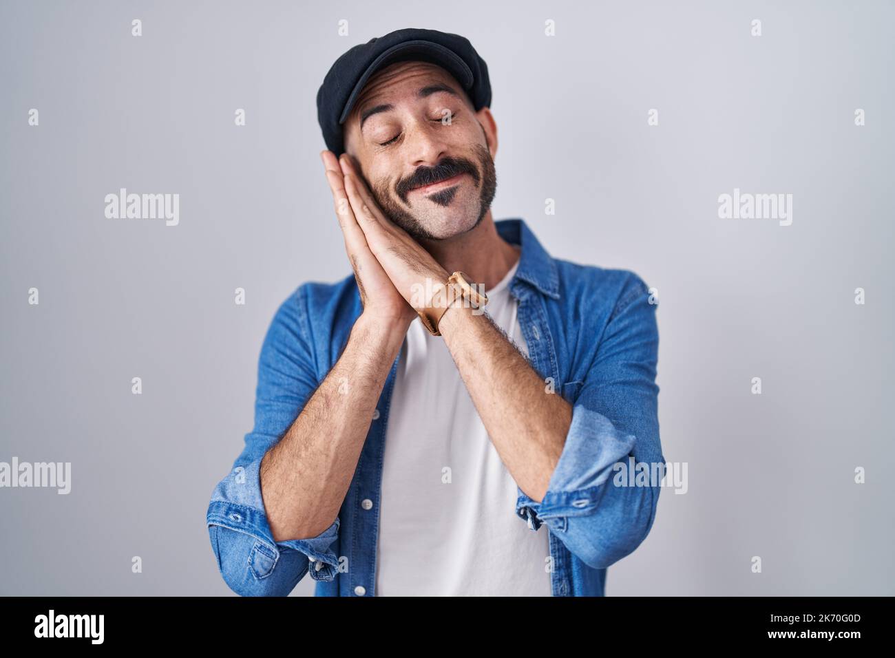Hispanic man with beard standing over isolated background sleeping ...