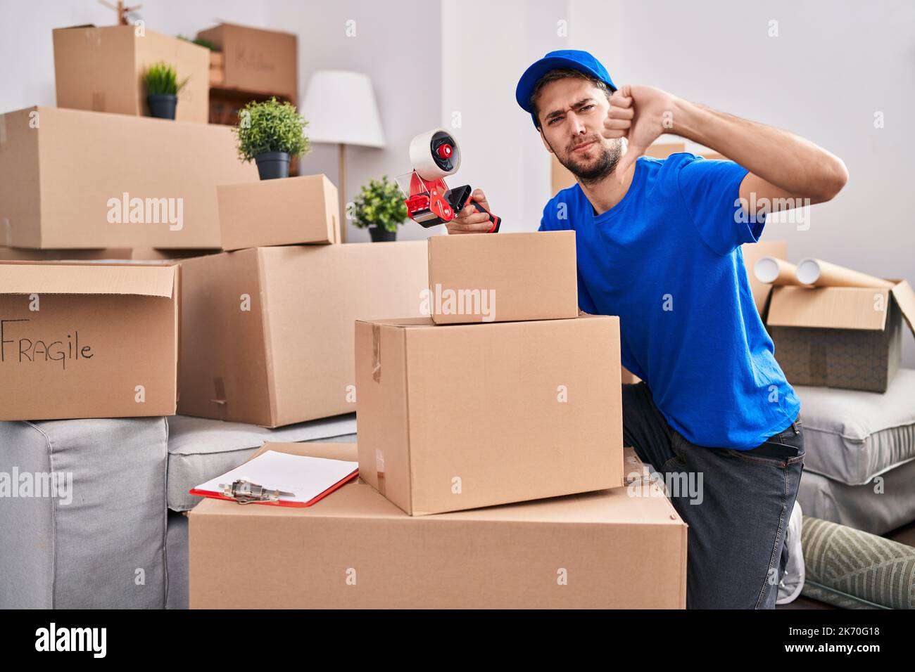 Hispanic man with beard working moving boxes with angry face, negative ...