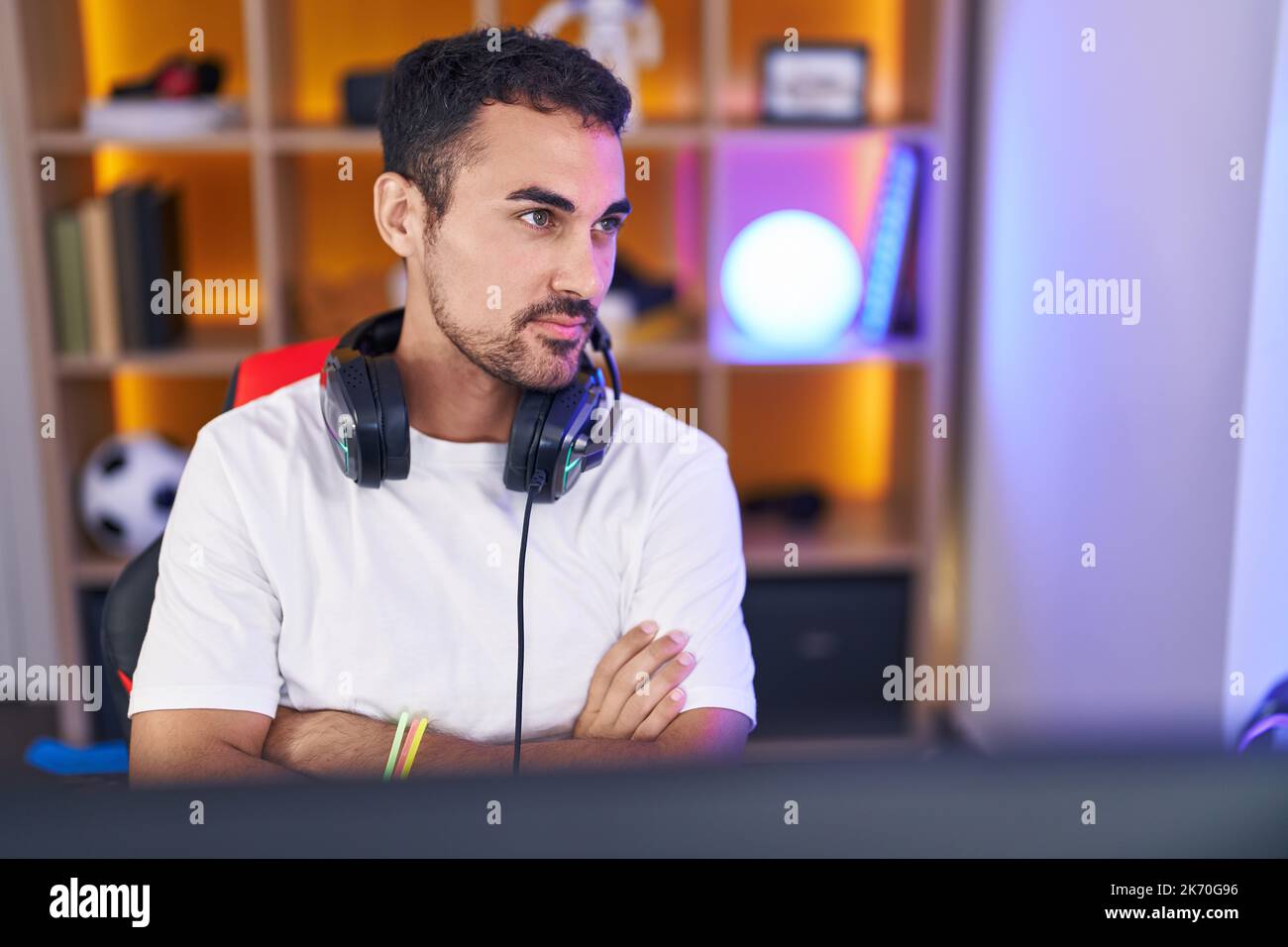 Young hispanic man streamer smiling confident sitting with arms crossed ...