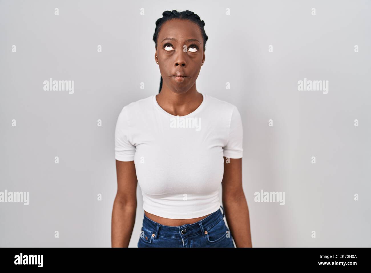 Beautiful black woman standing over isolated background making fish ...
