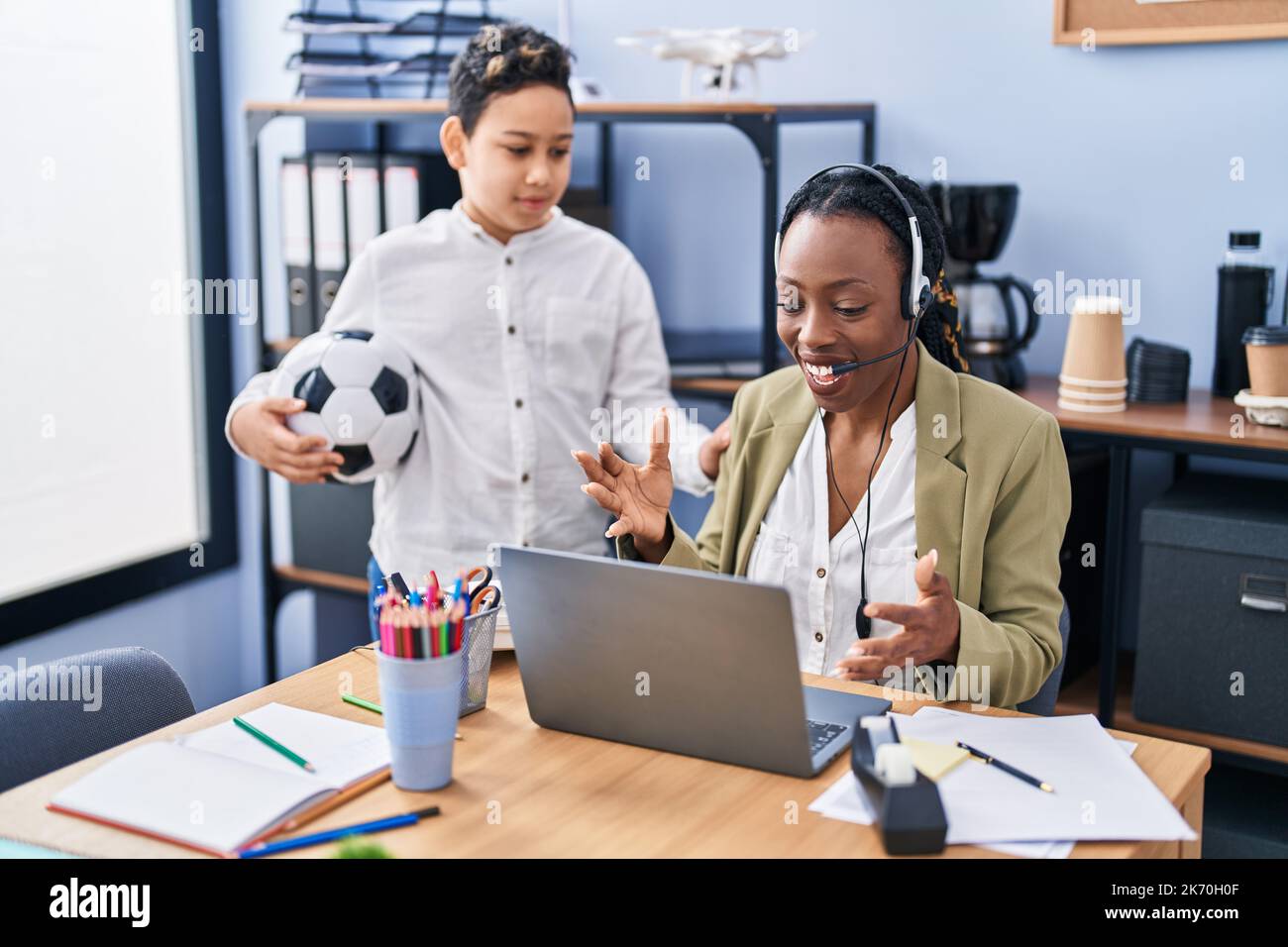 African american mother and son having video call working at office ...