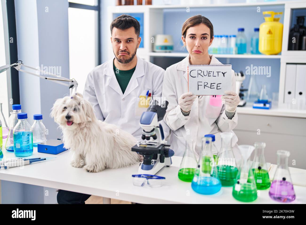 Young hispanic people working at scientist laboratory with dog ...