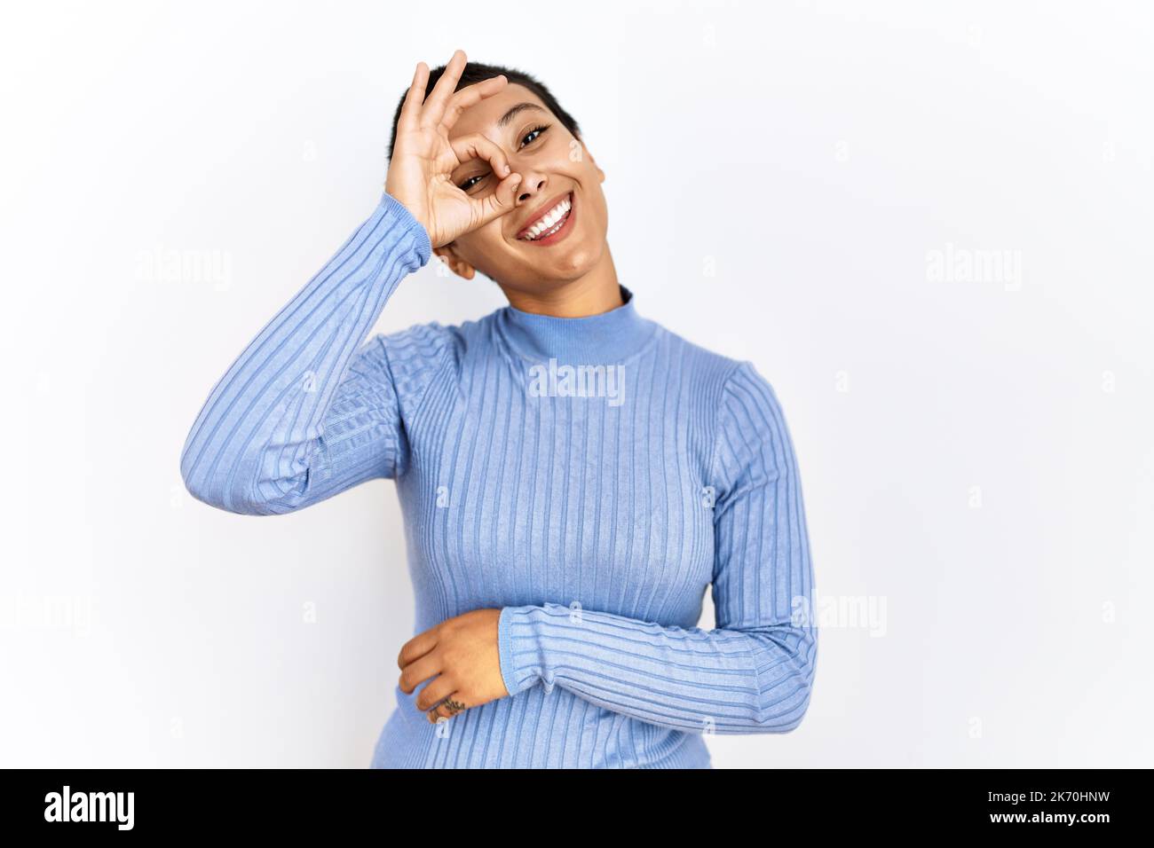 Young hispanic woman with short hair standing over isolated background ...
