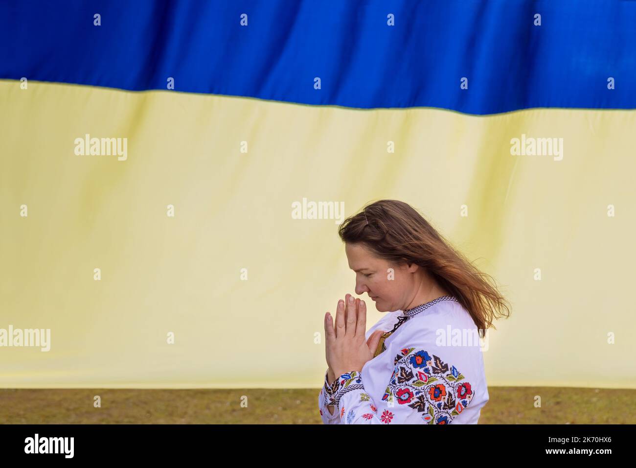 Prayer for Ukraine young woman prays for Ukraine near Ukrainian flag Stock Photo - Alamy