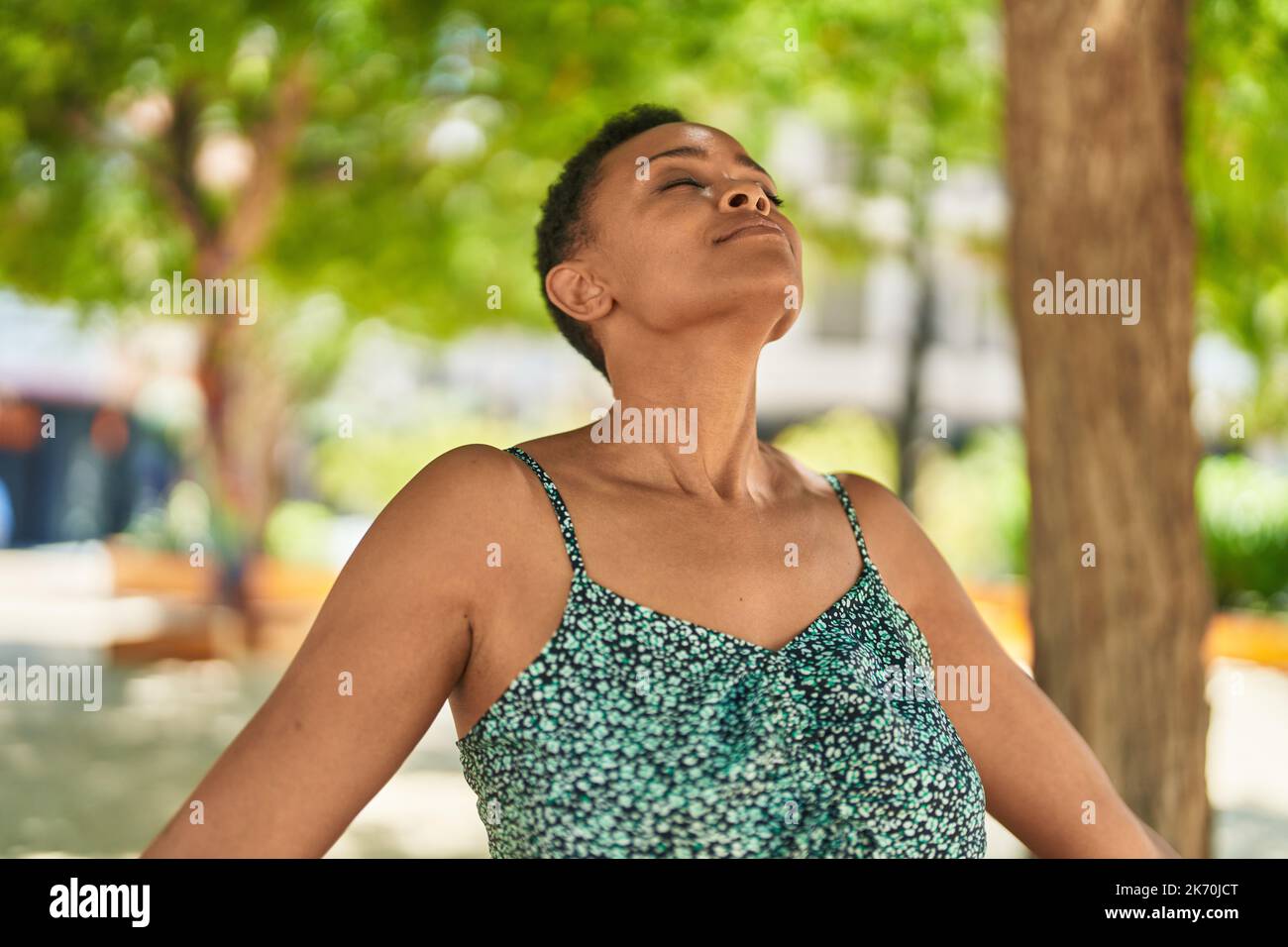 African american woman breathing with arms open at park Stock Photo - Alamy